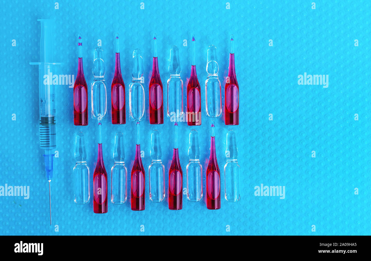 Syringe with a needle, red and white ampoules for injection. Medicine ...