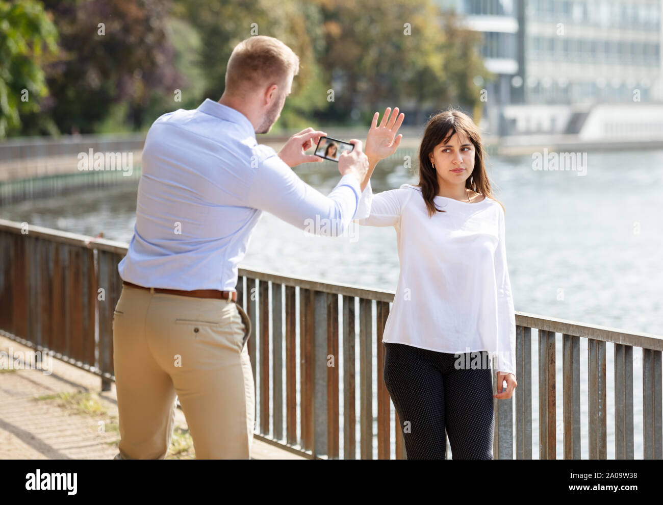 Young Woman Refusing Man Taking Photo Of Her On Mobile Phone Stock ...