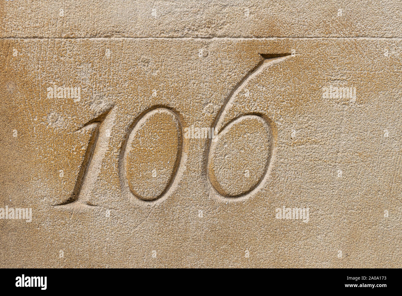 Number 106 carved in a limestone ashlar wall Stock Photo - Alamy