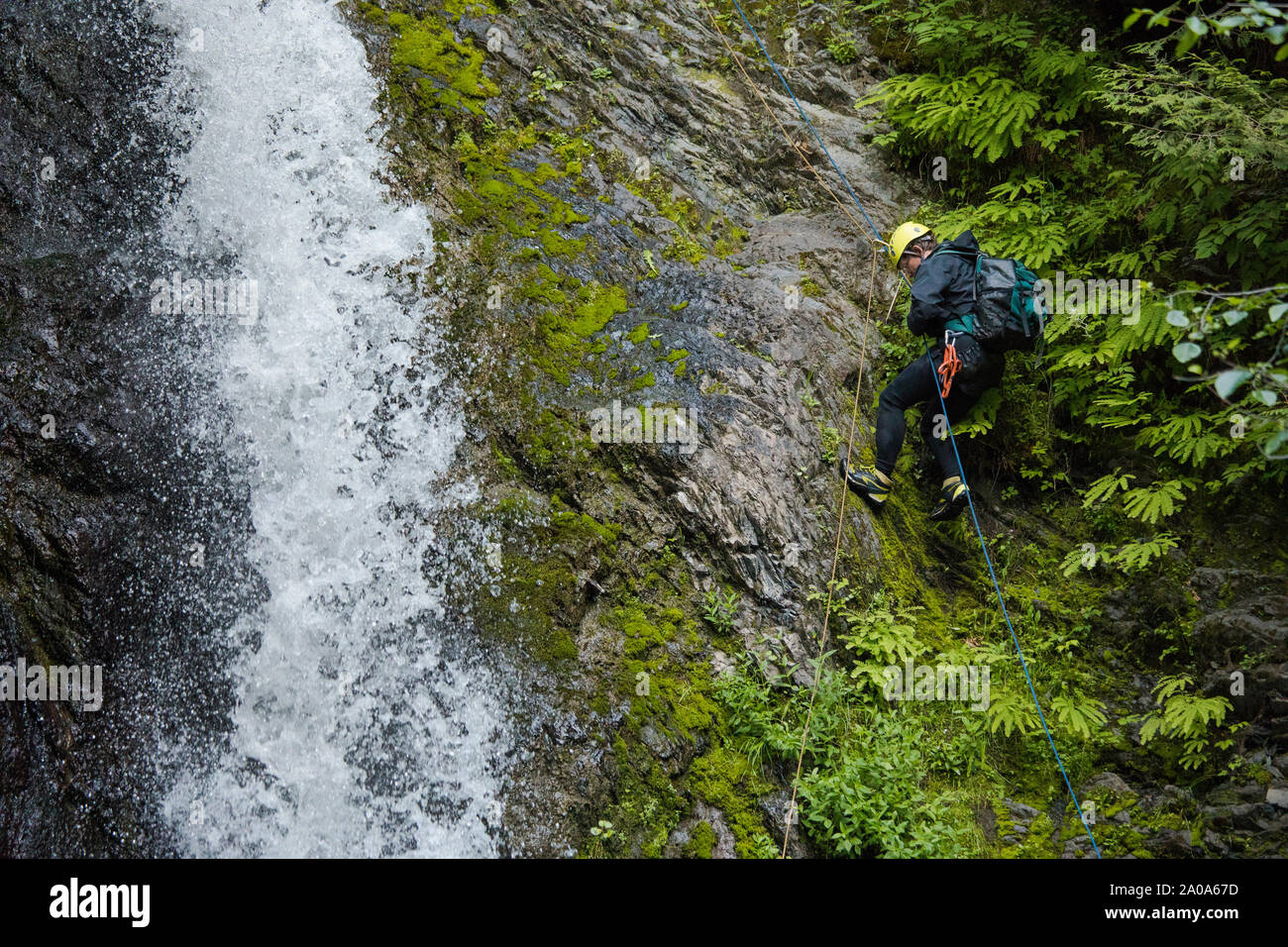 Side view of man rappelling beside waterfall in Canyon Stock Photo - Alamy