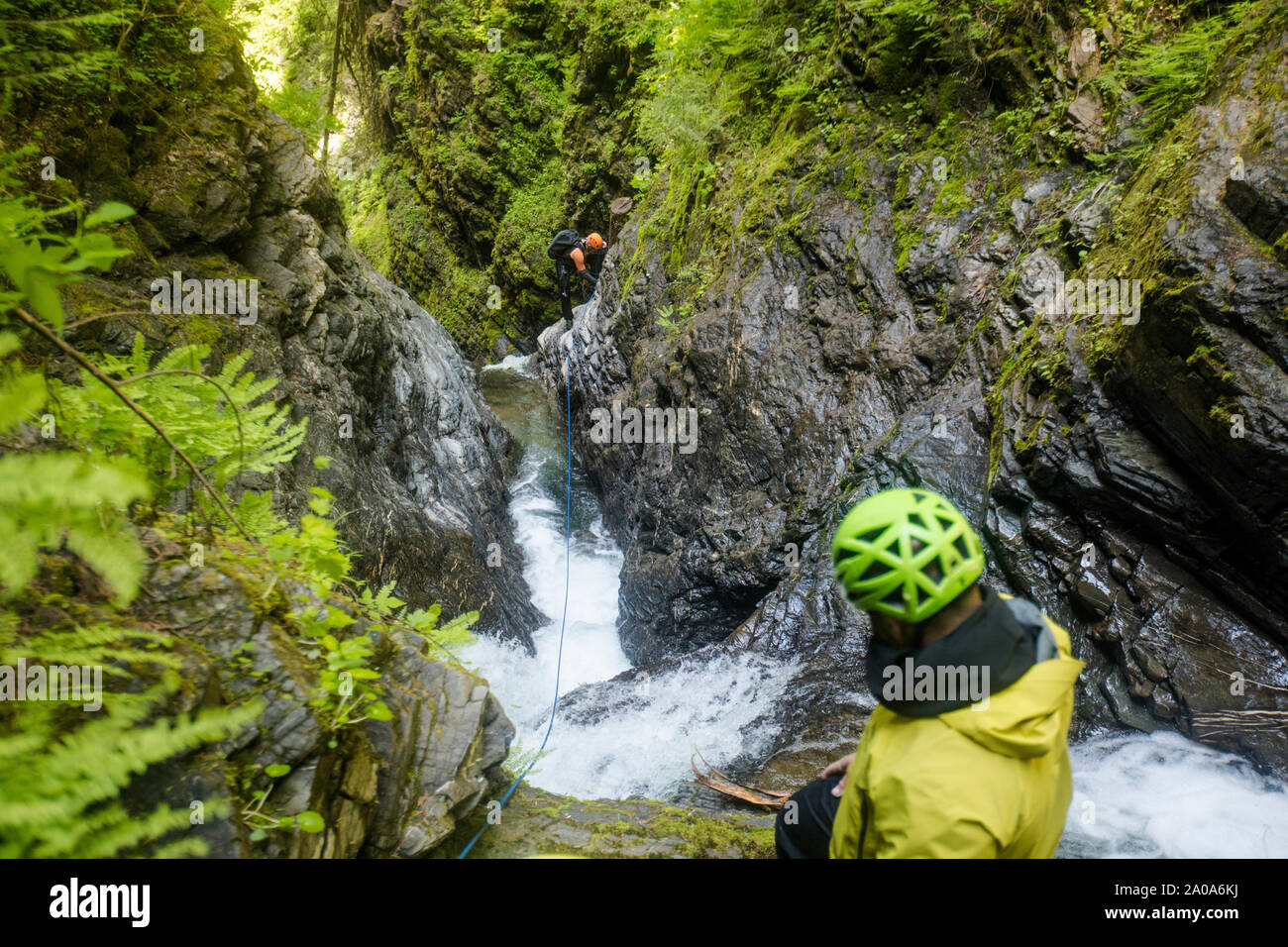 Adventurous men carefully maneuver through a tricky slot canyon Stock ...