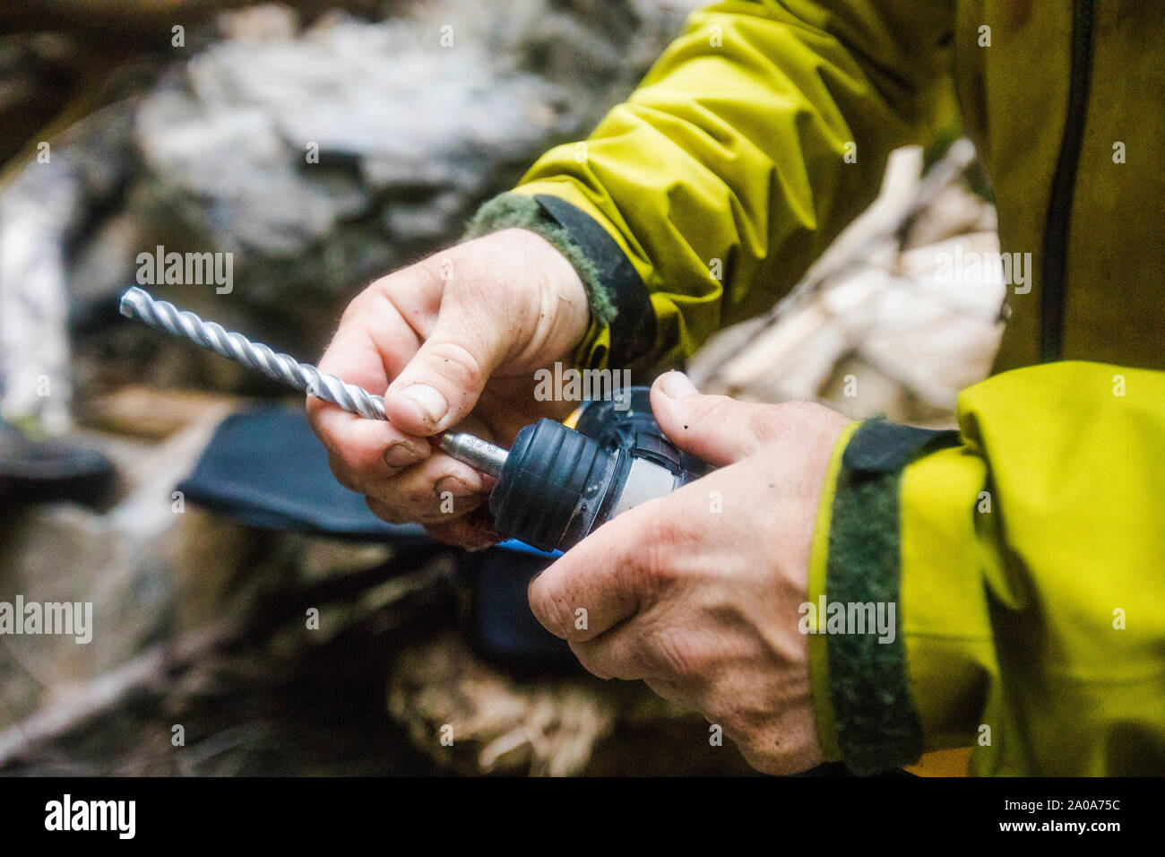 Detail of man placing drill bit into drill Stock Photo - Alamy