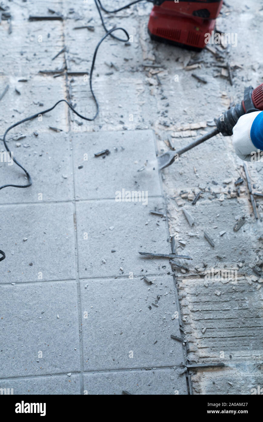 detail view of a construction worker using a handheld demolition hammer ...