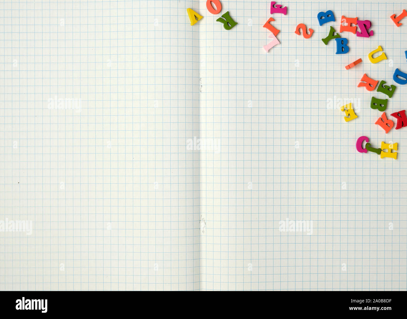 open notebook with white sheets in a box and small multi-colored wooden ...