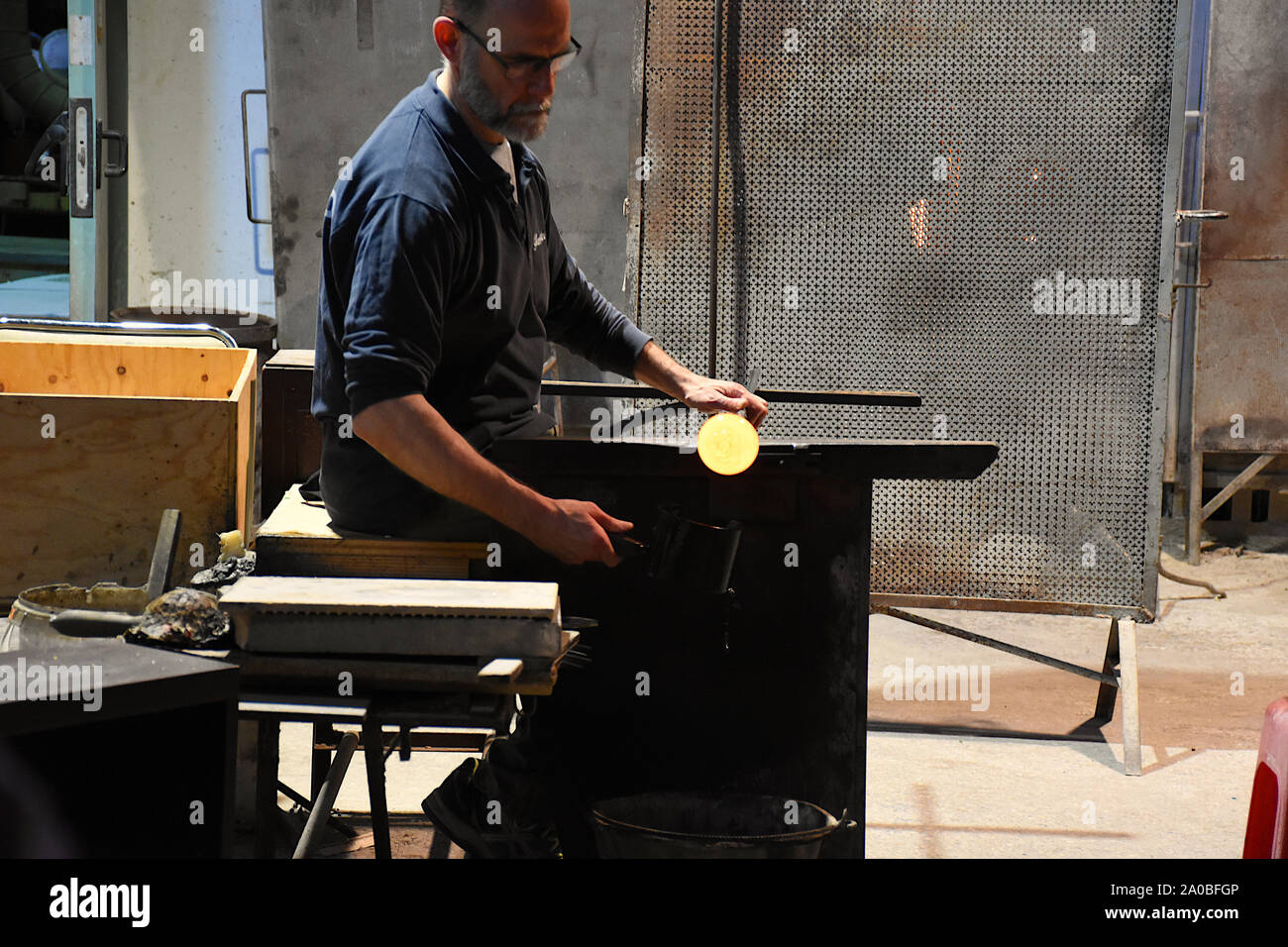 Glass blower forming, turning heated glass into a beautiful, decorative ...