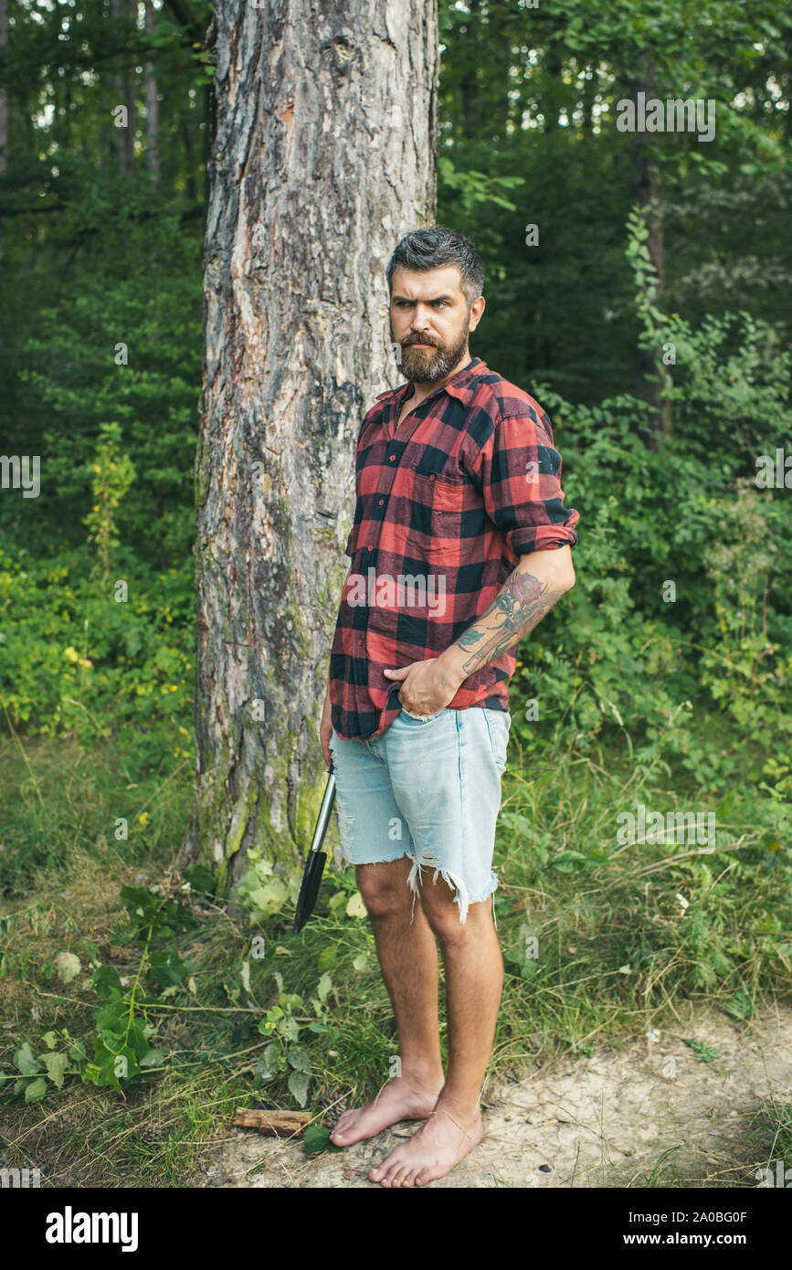 Bearded man in woods. Brutal lumberjack waiting on path. Barefoot ...