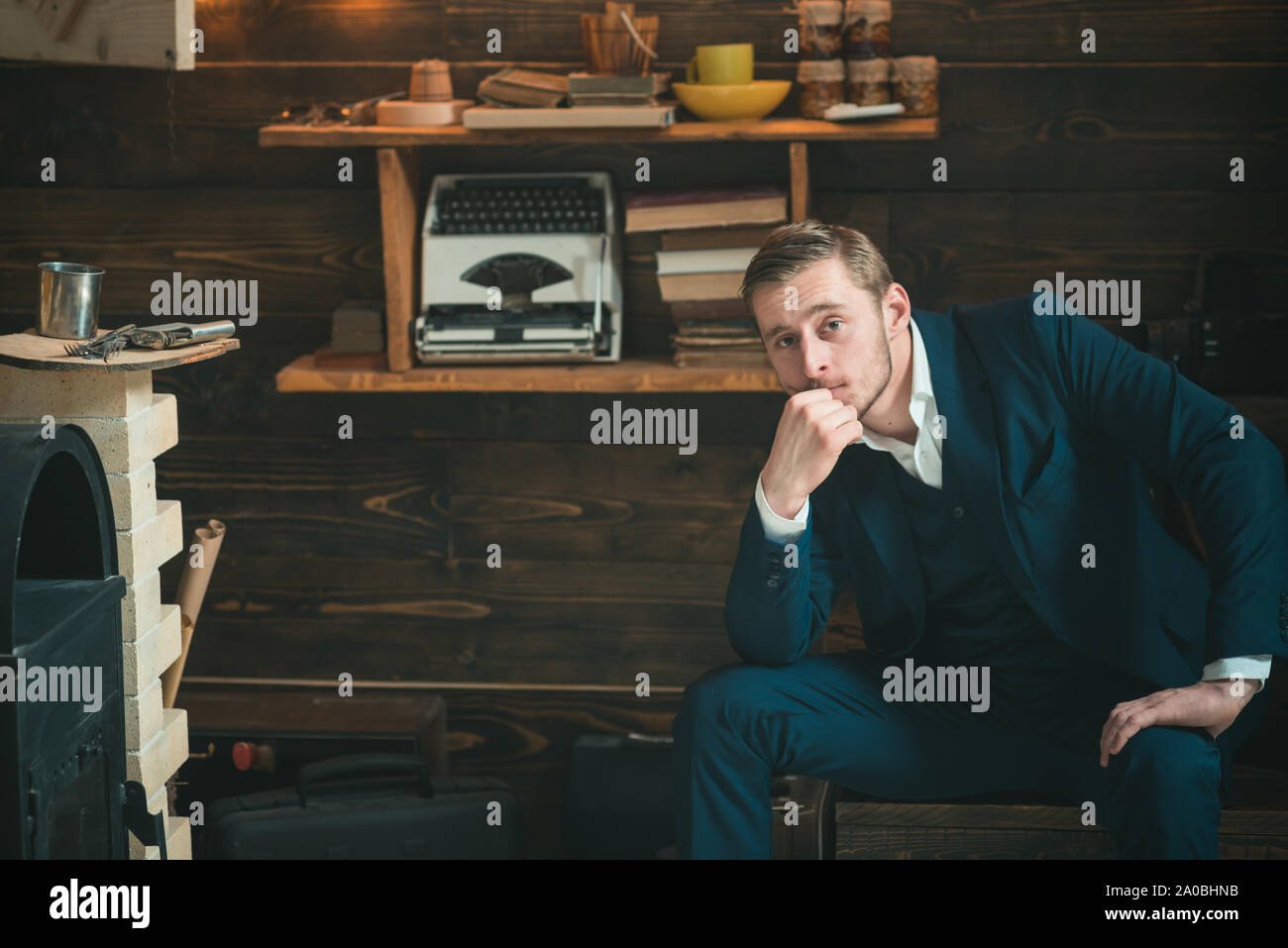 Smart guy sitting in study room. Bearded blond man in blue suit leaning ...