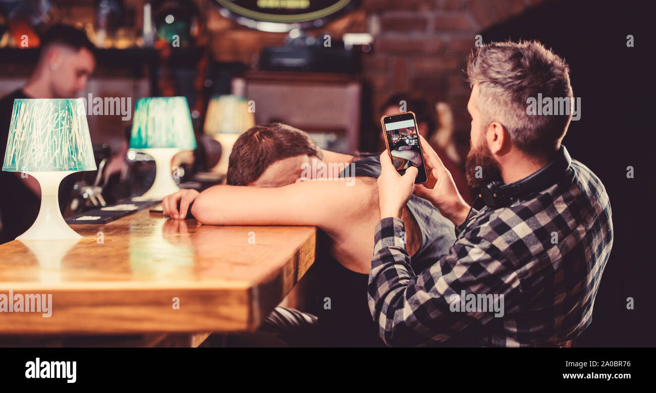 Hipster taking photo drunk friend. Drunk friends in bar. Fall asleep at ...