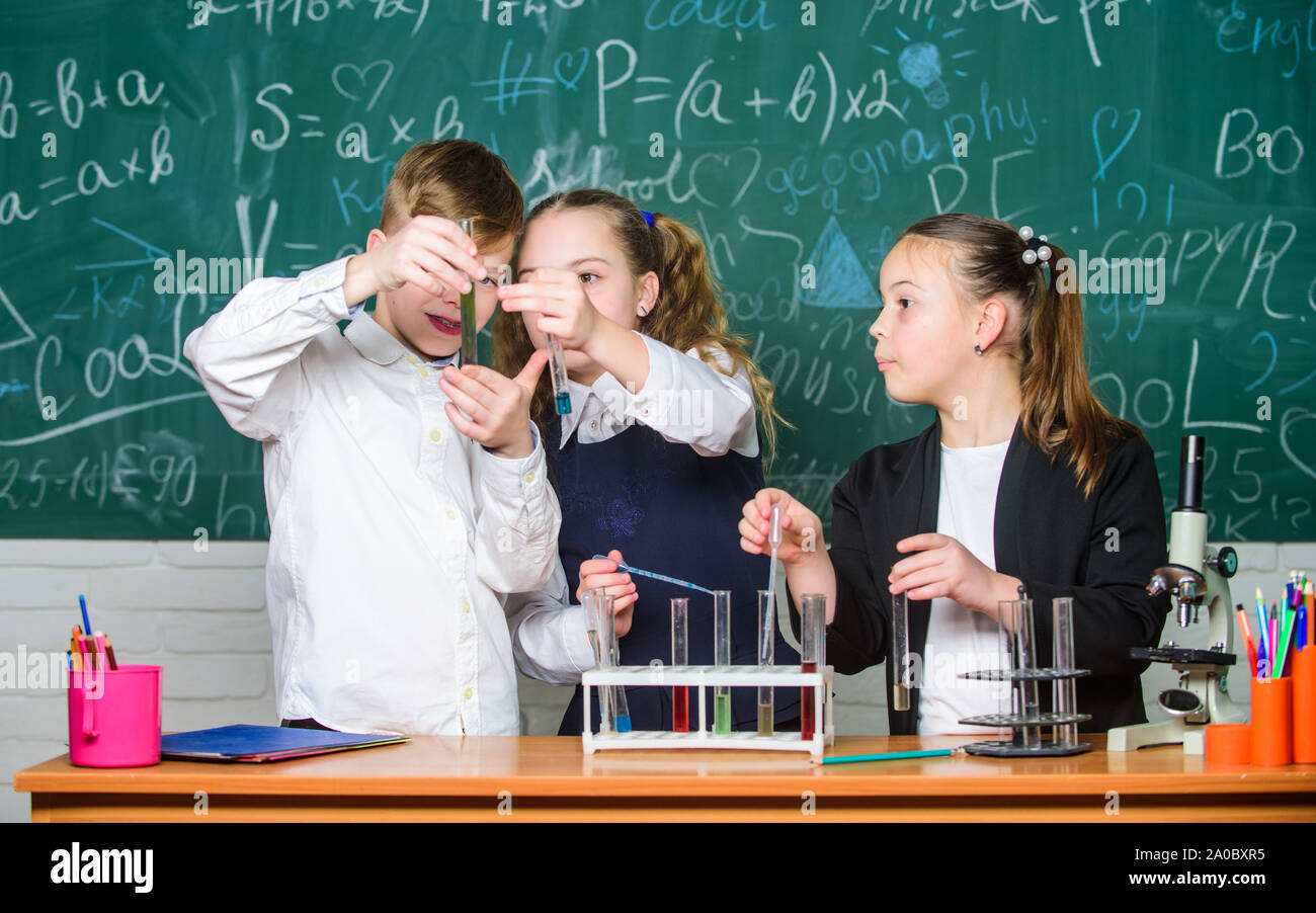 Test tubes with colorful substances. Girls and boy student conduct ...