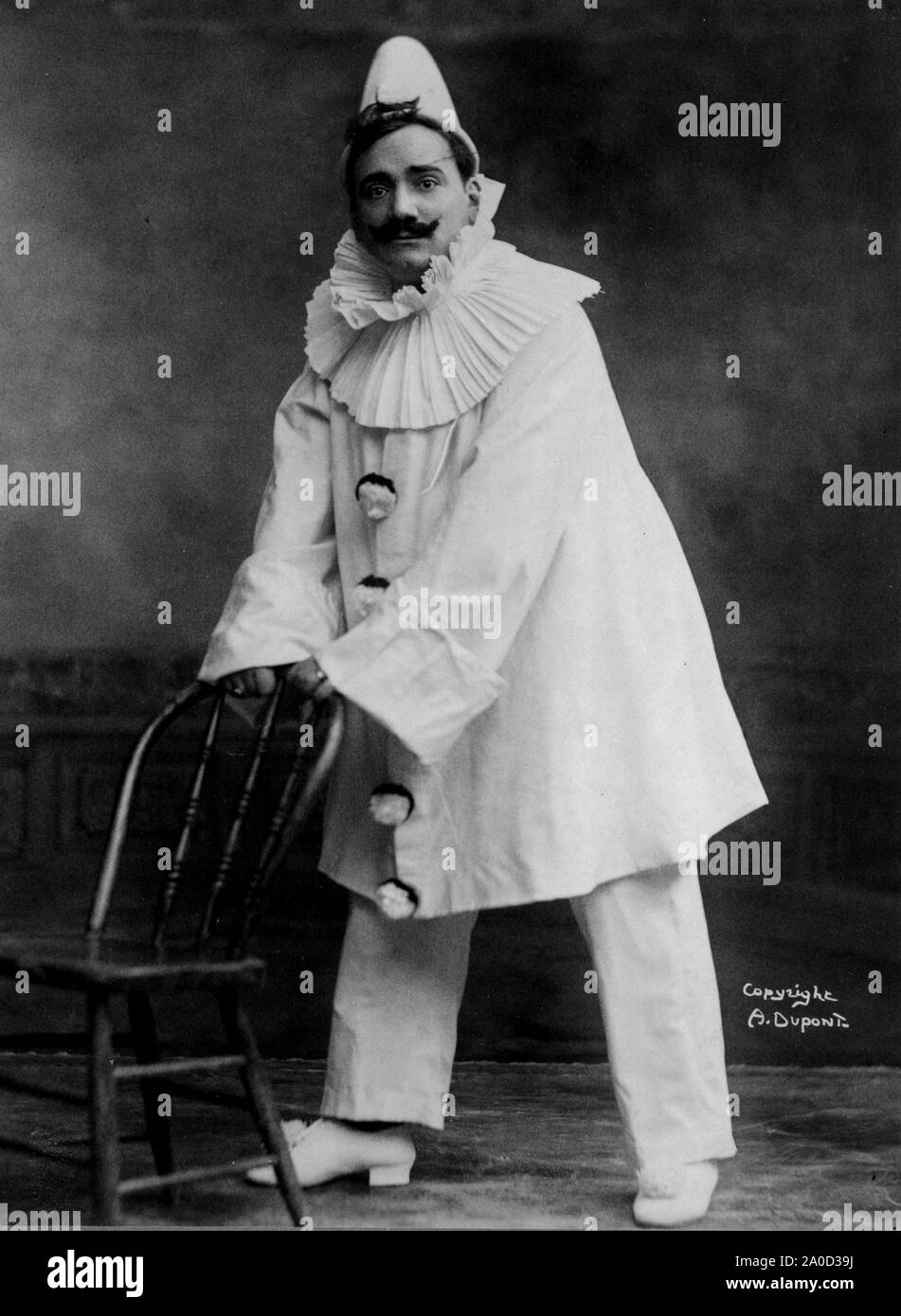 Opera star Enrico Caruso, dressed as a clown, holding the back of a ...