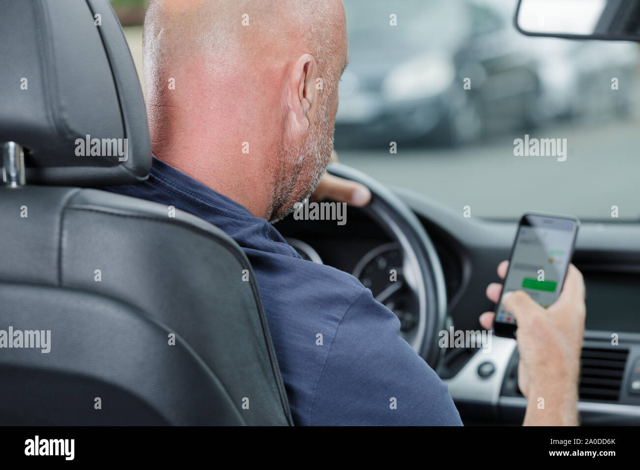 man uses his phone while driving Stock Photo - Alamy
