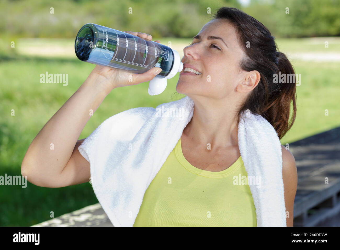 woman taking a break to drink from water bottle Stock Photo - Alamy