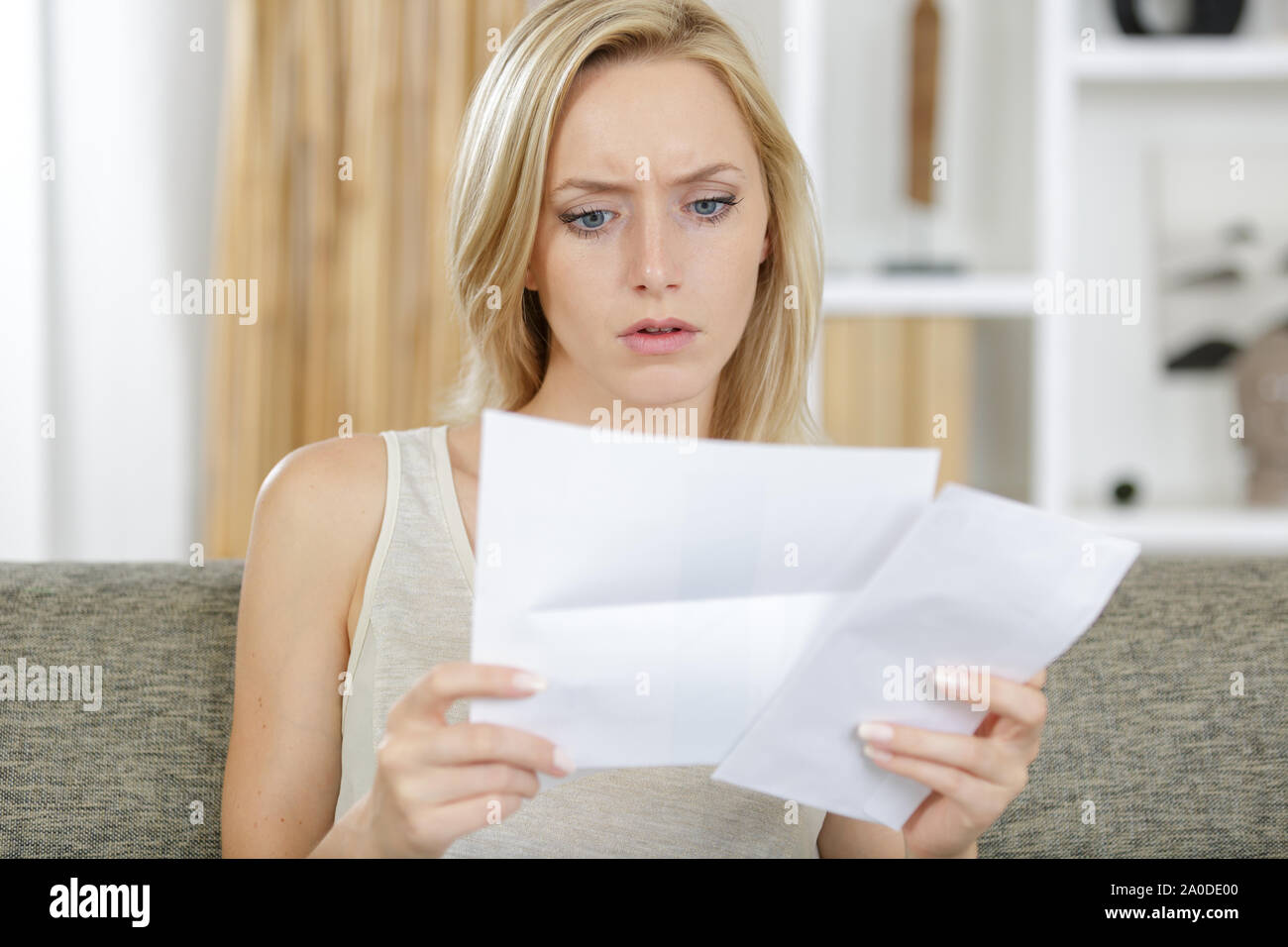 woman reading a letter with a concerned expression Stock Photo - Alamy