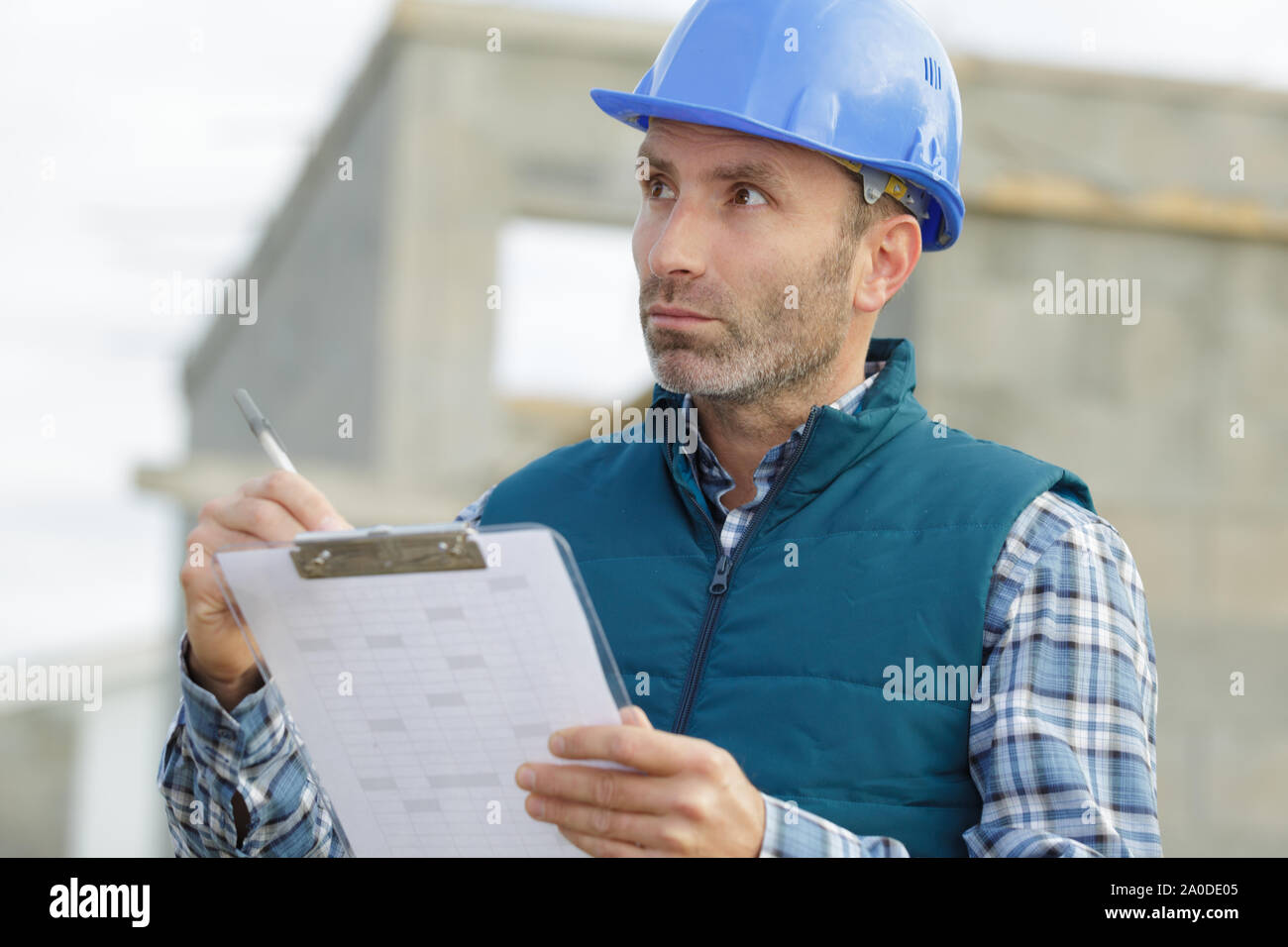 male builder in hard hat with clipboard Stock Photo - Alamy