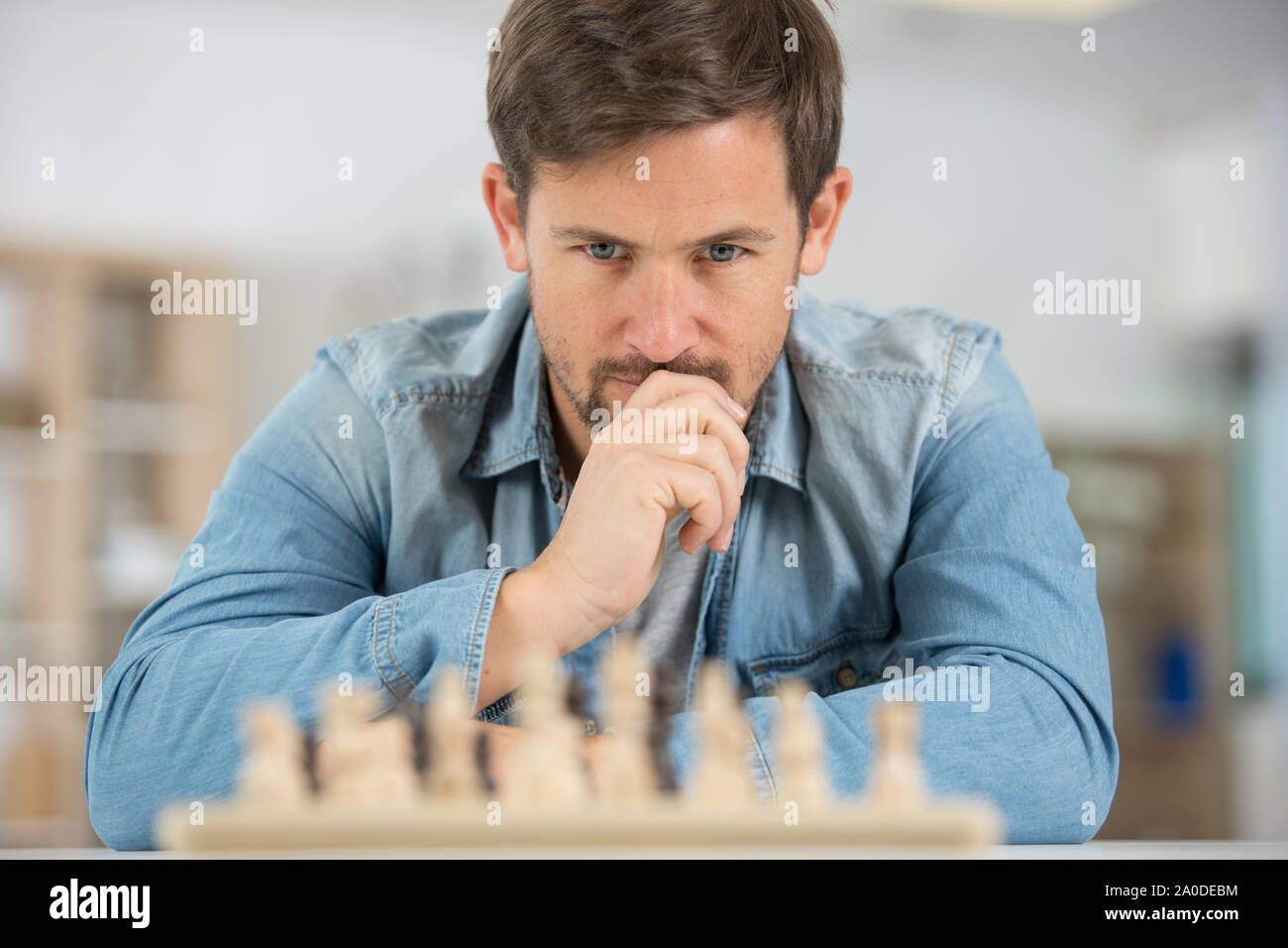 young man is thinking while playing chess Stock Photo - Alamy