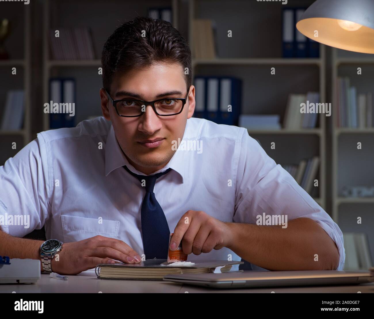 The businessman staying late in office for drugs Stock Photo - Alamy
