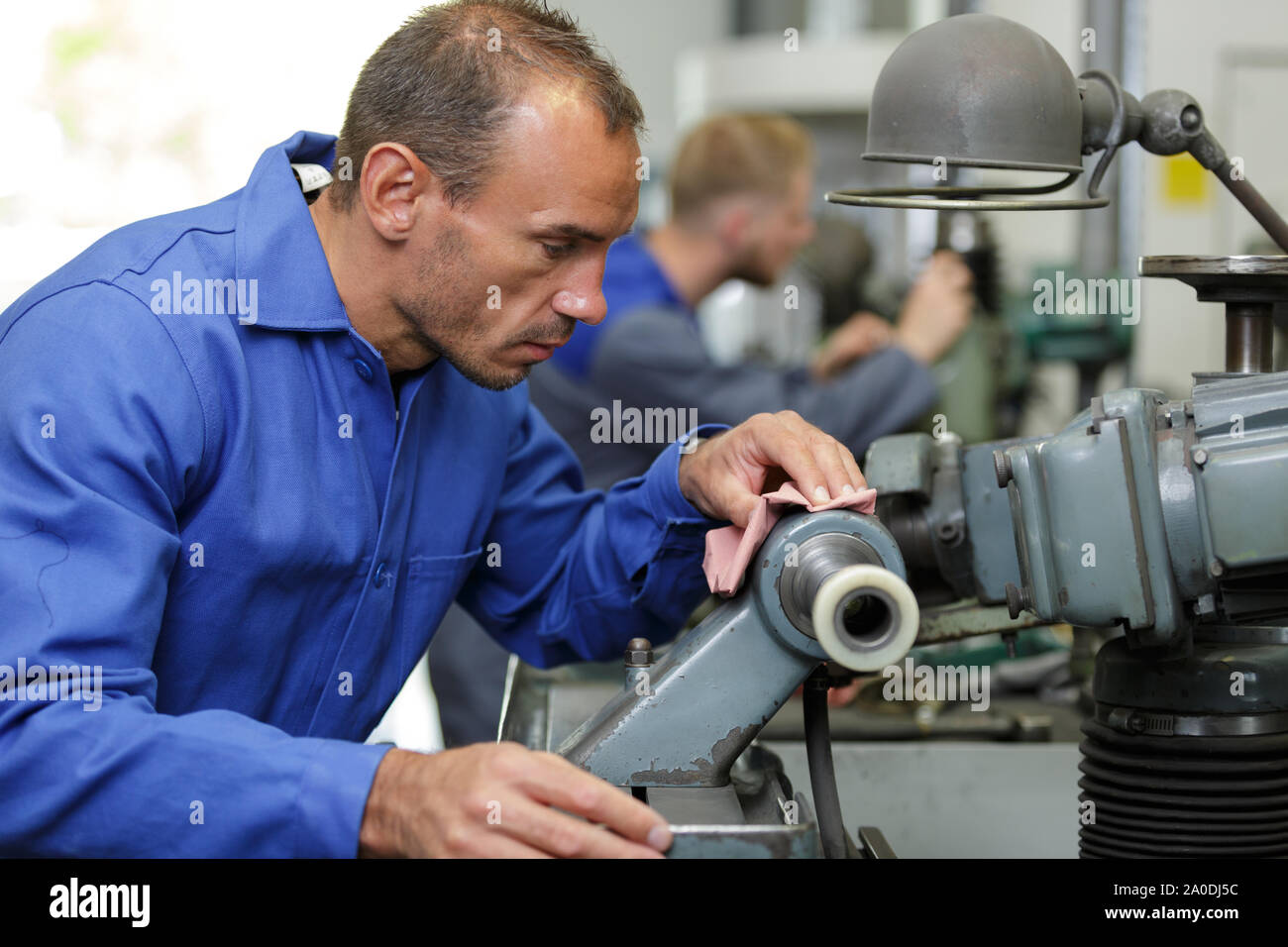 engineer cleaning factory machinery with paper towel Stock Photo - Alamy