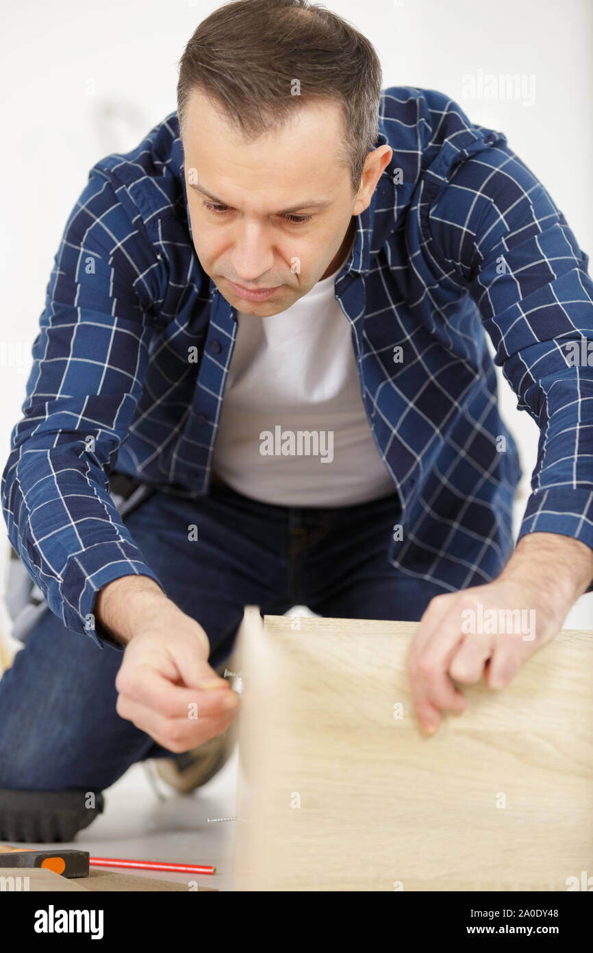 man aassembling diy their own wood furniture Stock Photo - Alamy