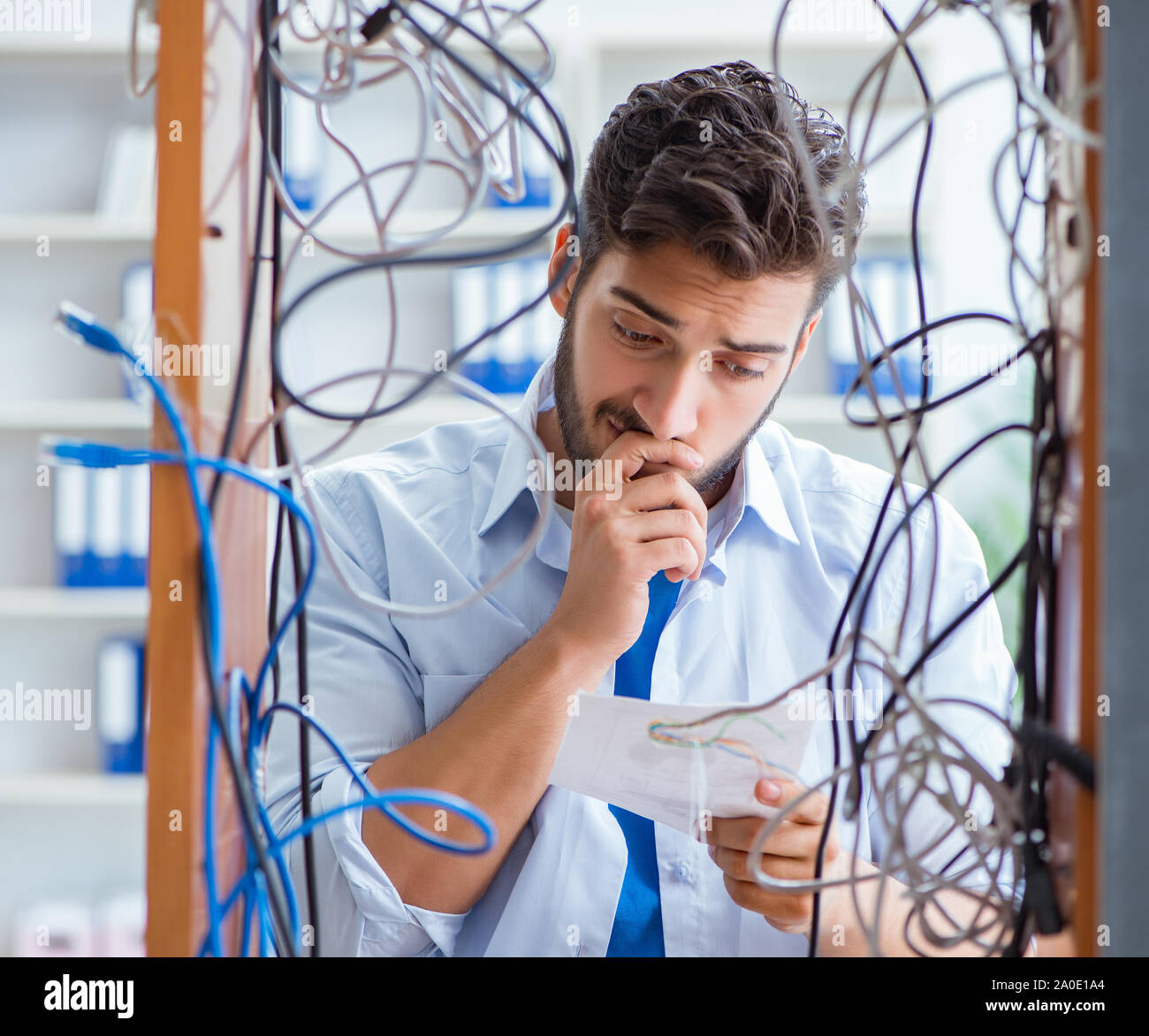 The electrician trying to untangle wires in repair concept Stock Photo ...