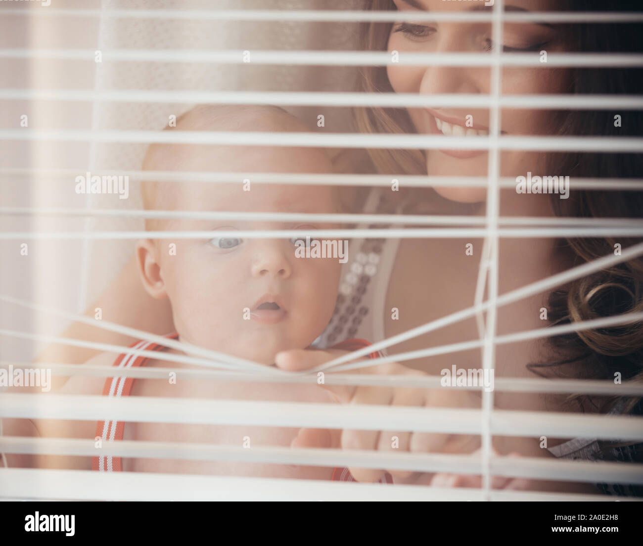 Woman with child smile at window shutters. Baby son and mother open ...