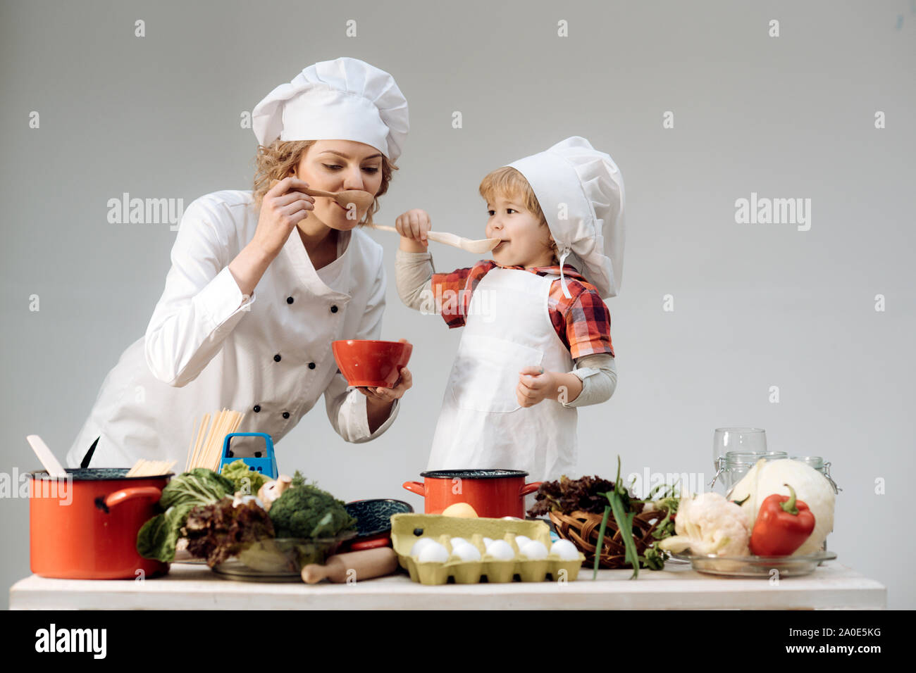 Chef and assistant near kitchen equipment and food products. Mother ...