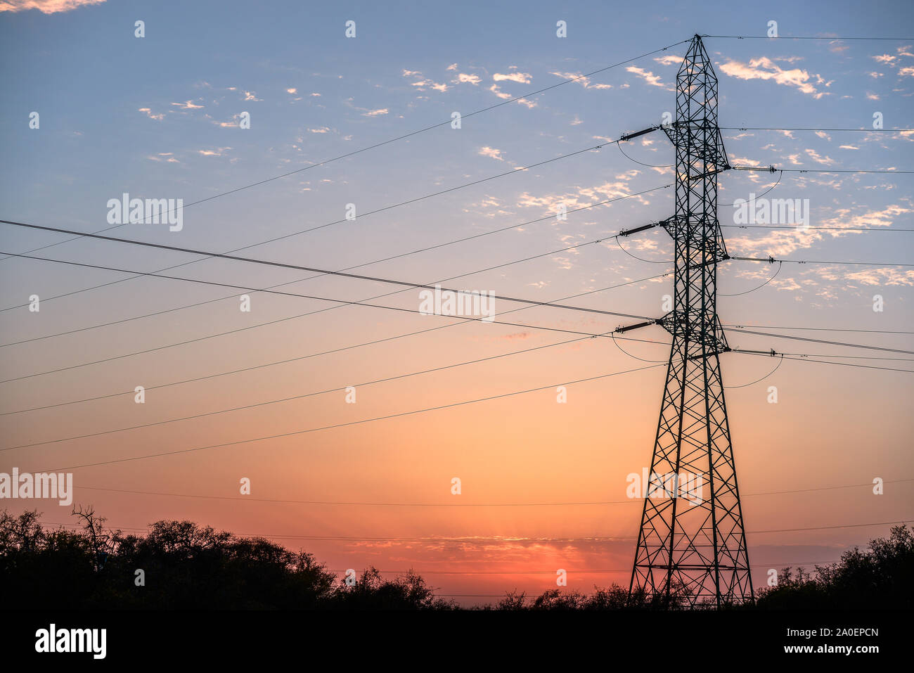 High-voltage electricity tower with sunset sky Stock Photo - Alamy