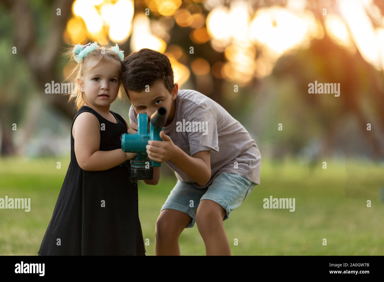 Cute little children paying with green appliance Stock Photo - Alamy