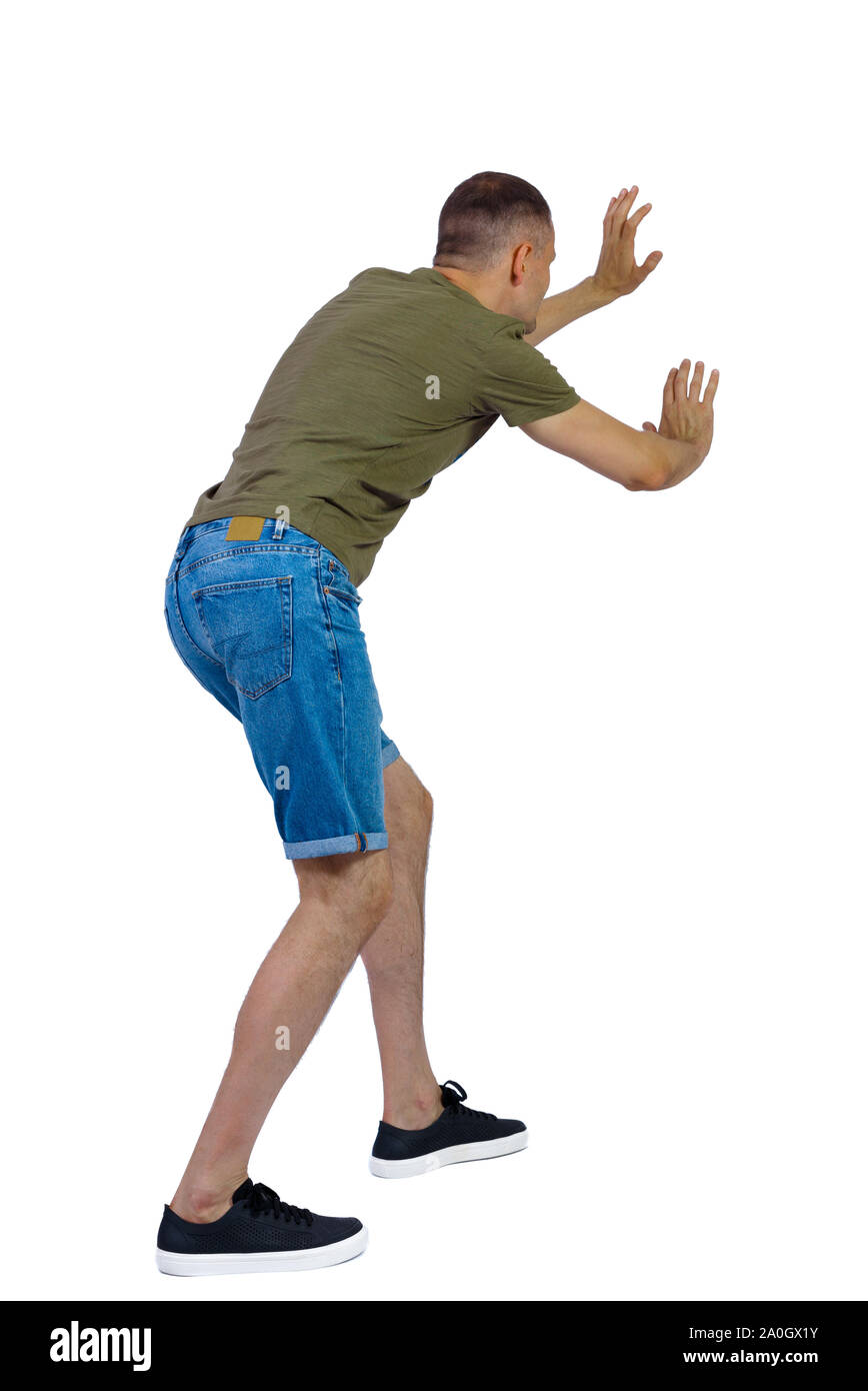 back view of man in shorts pushes wall. Isolated over white background ...