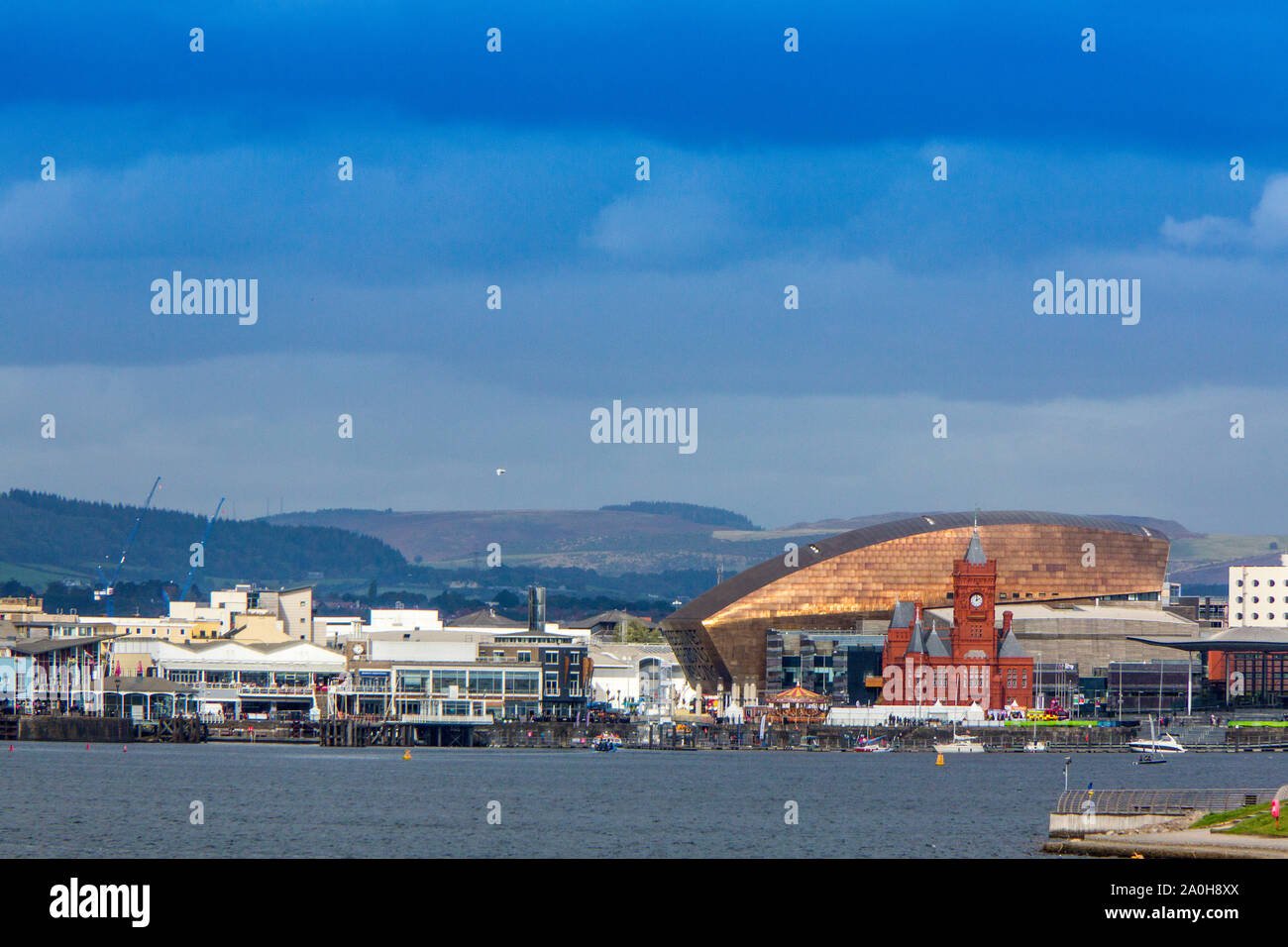 A shaft of sunlight lights up the Millennium Centre and red brick ...