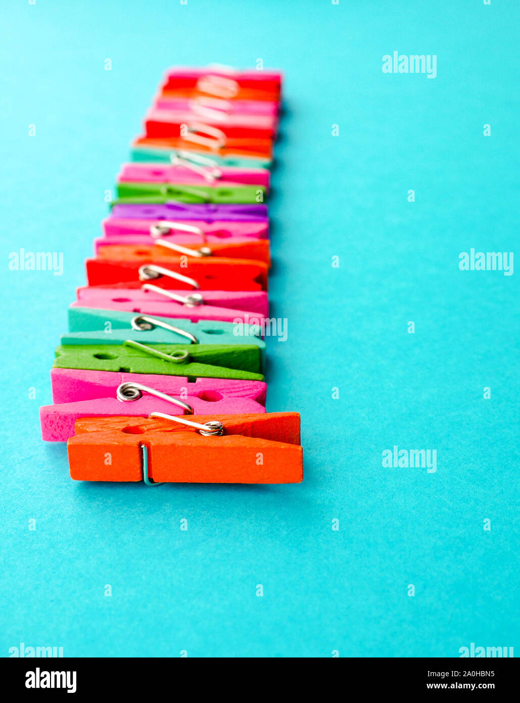 A lot of colored wooden clothespins with long shadows, isolated on a ...