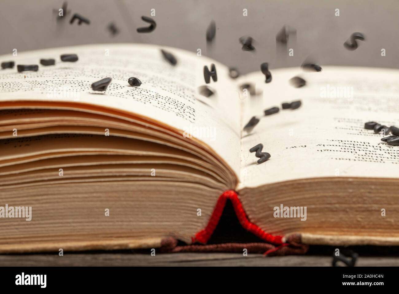 Letters fall into an old open book Stock Photo - Alamy
