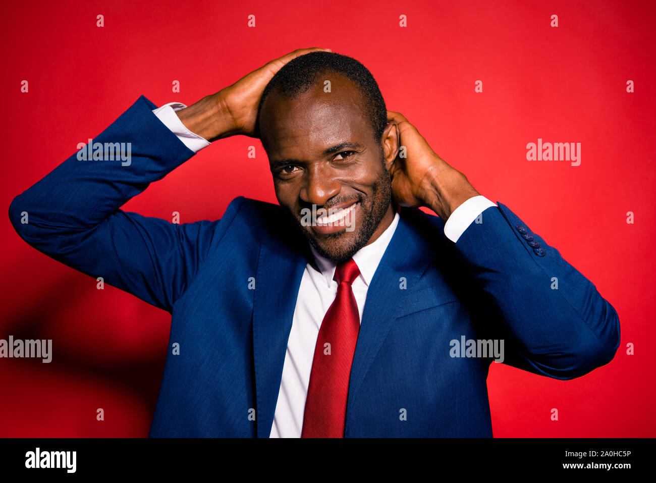 Careless carefree sophisticated man in blue formal wear isolated on red ...