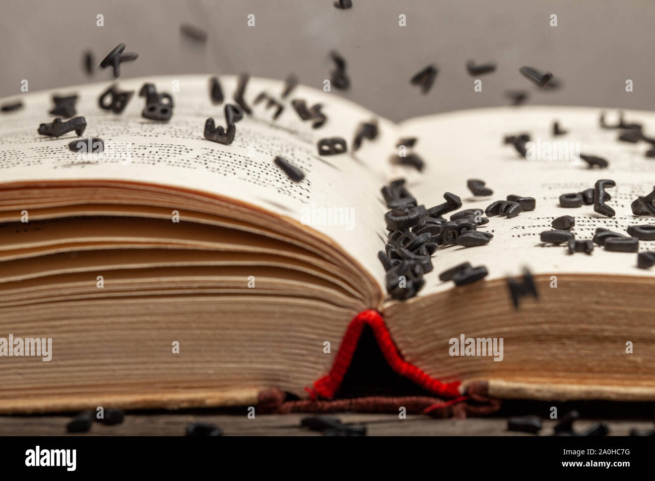 Letters fall into an old open book Stock Photo - Alamy