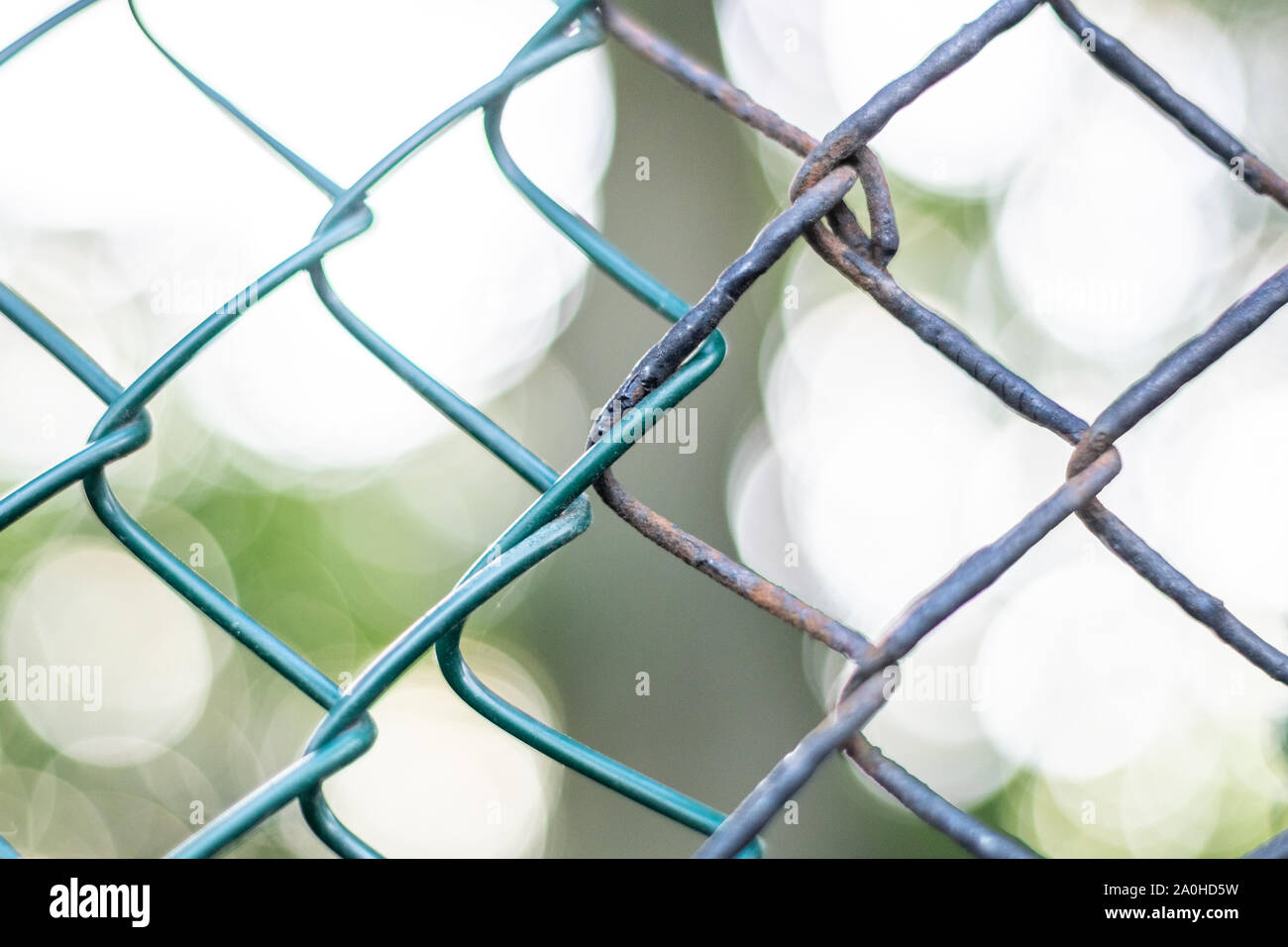 New Chain link next to an old chain link fence with a bokeh background ...