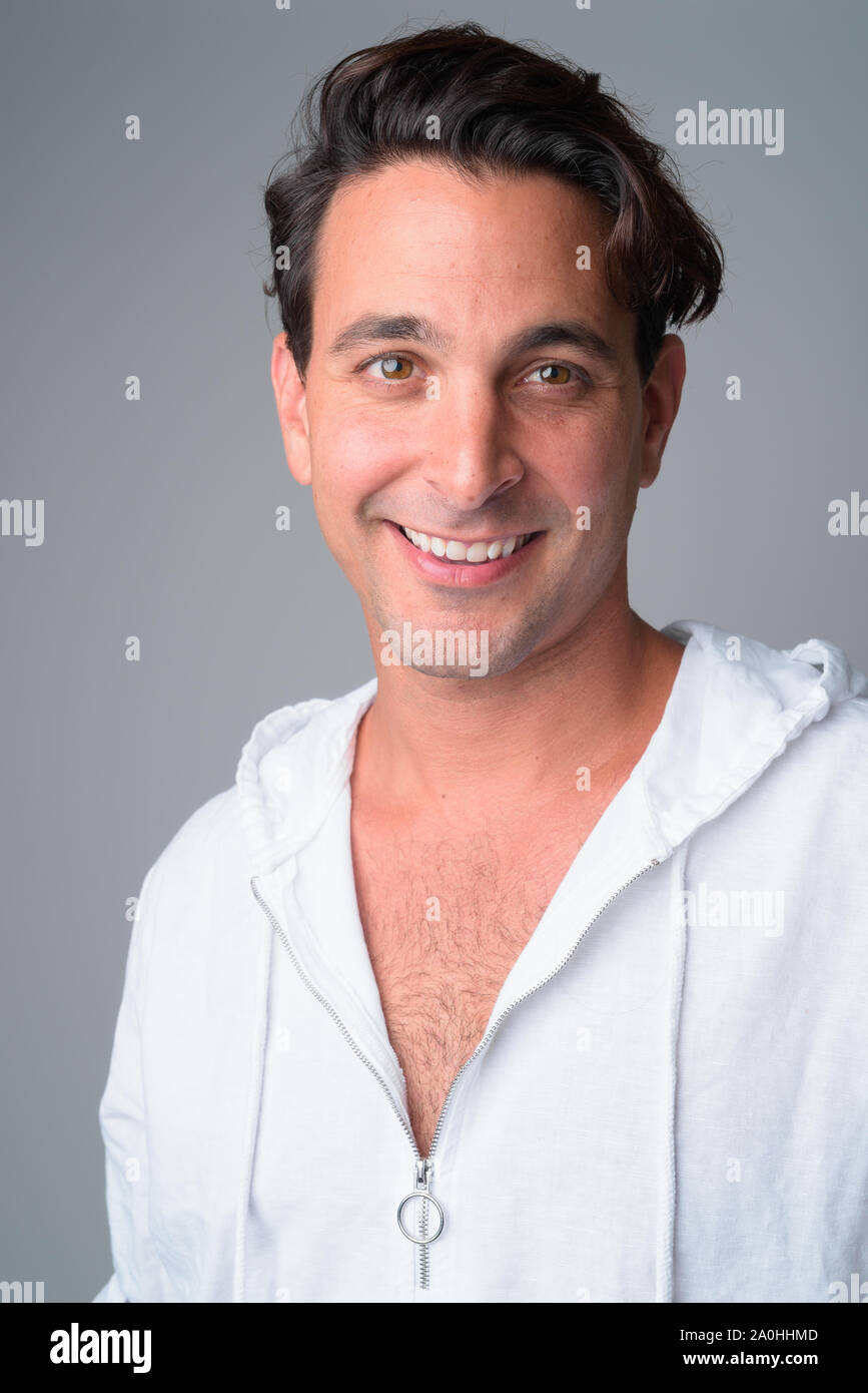 Face of happy handsome Hispanic man thinking Stock Photo - Alamy