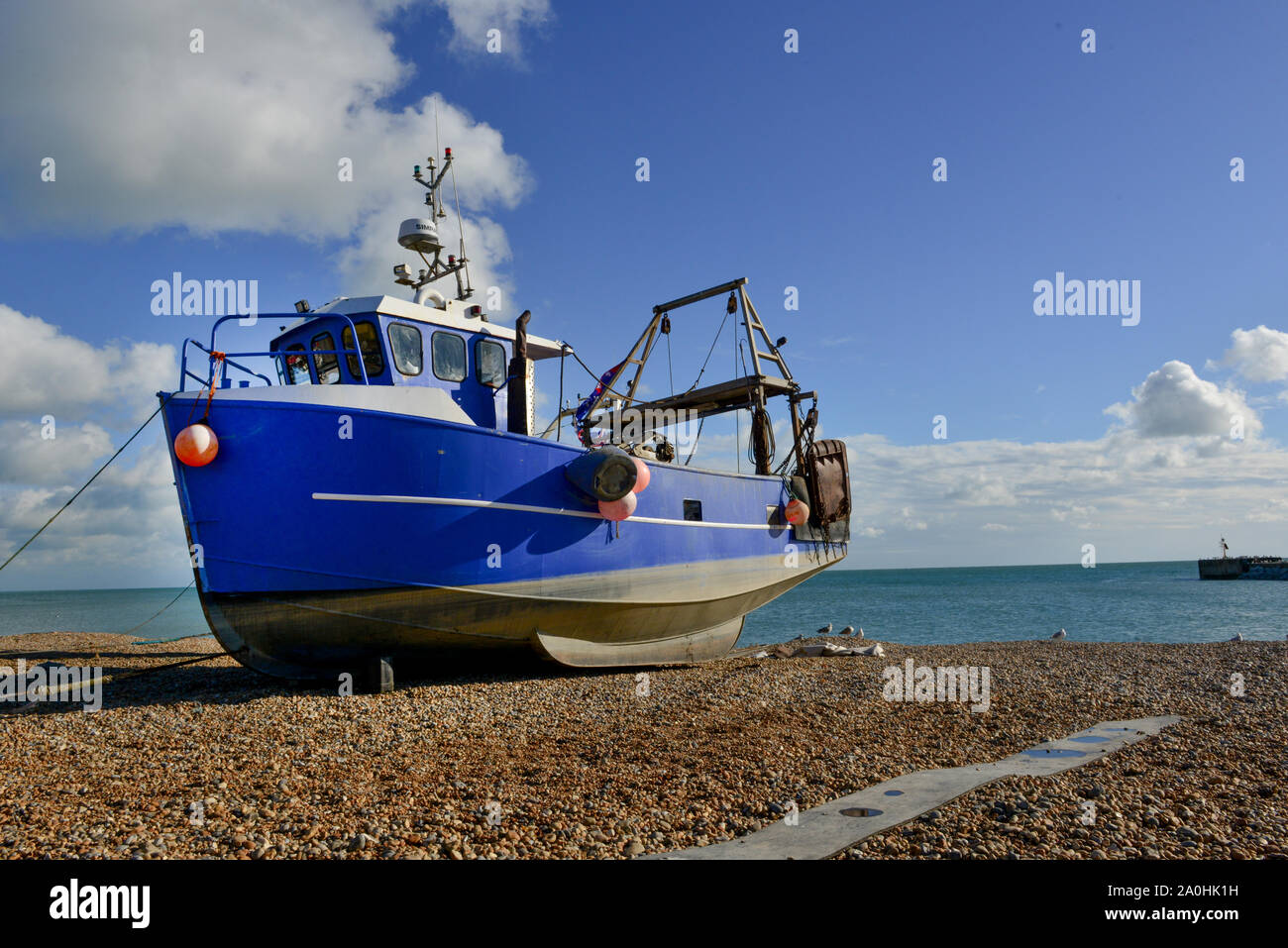 a single beached fishing boat on single beach Stock Photo - Alamy