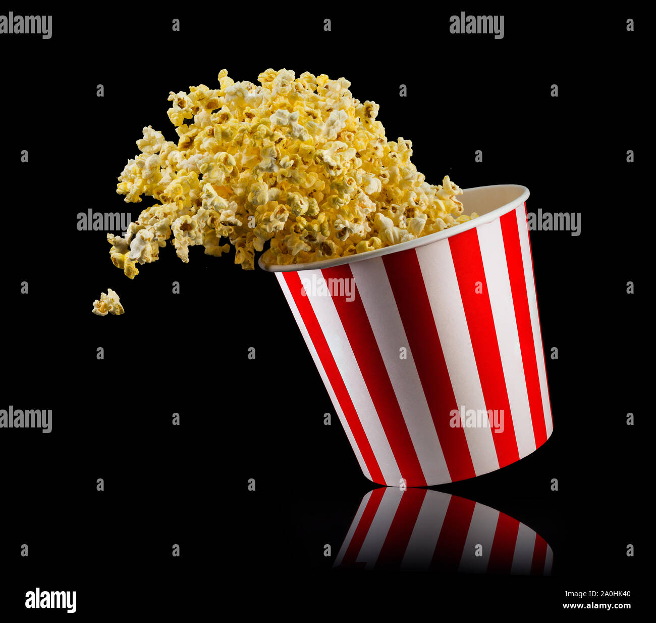 Flying popcorn from striped bucket isolated on black background Stock ...