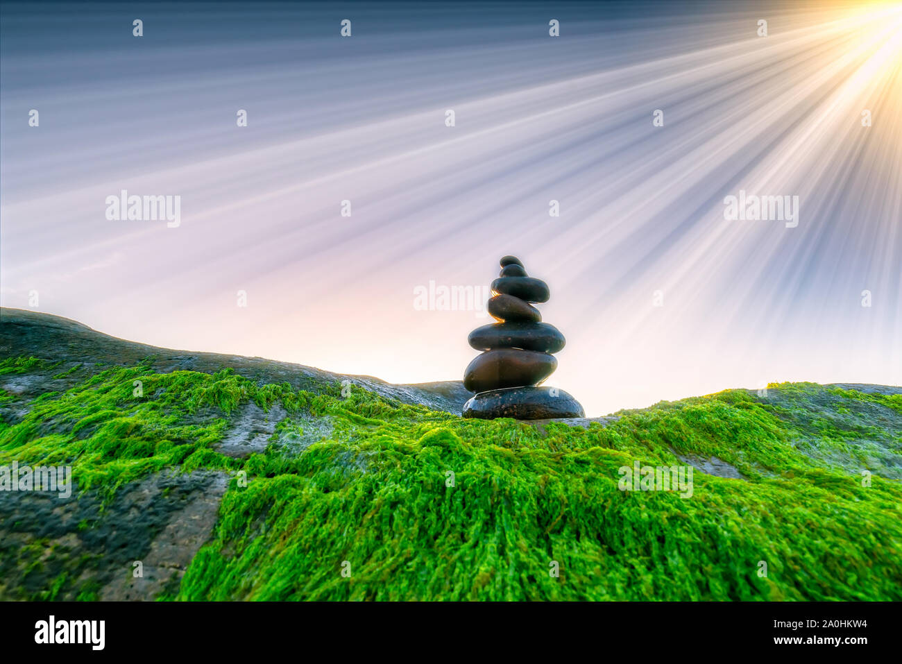 Stacked Pebbles art on mossy rocks welcomes beautiful new day Stock ...