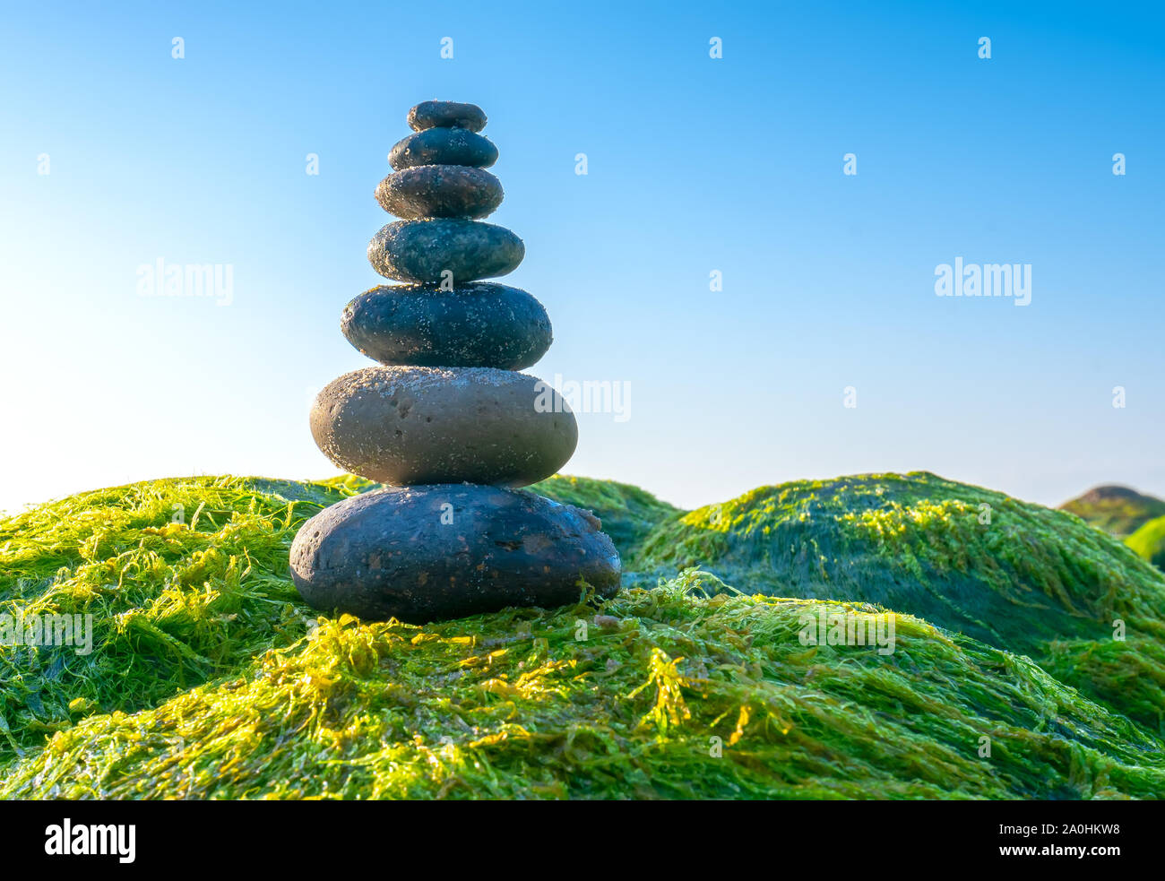 Stacked Pebbles art on mossy rocks welcomes beautiful new day Stock ...