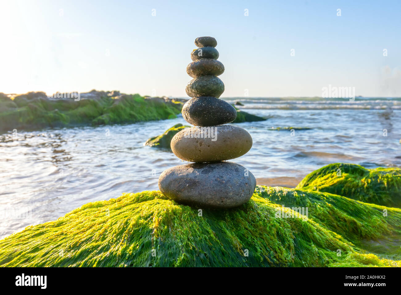 Stacked Pebbles art on mossy rocks welcomes beautiful new day Stock ...