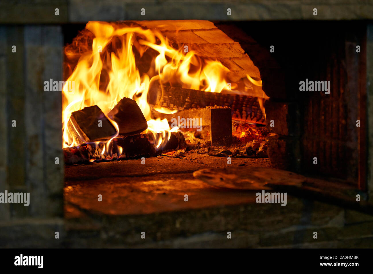 Pizzeria stove with flame and wood branding Stock Photo - Alamy