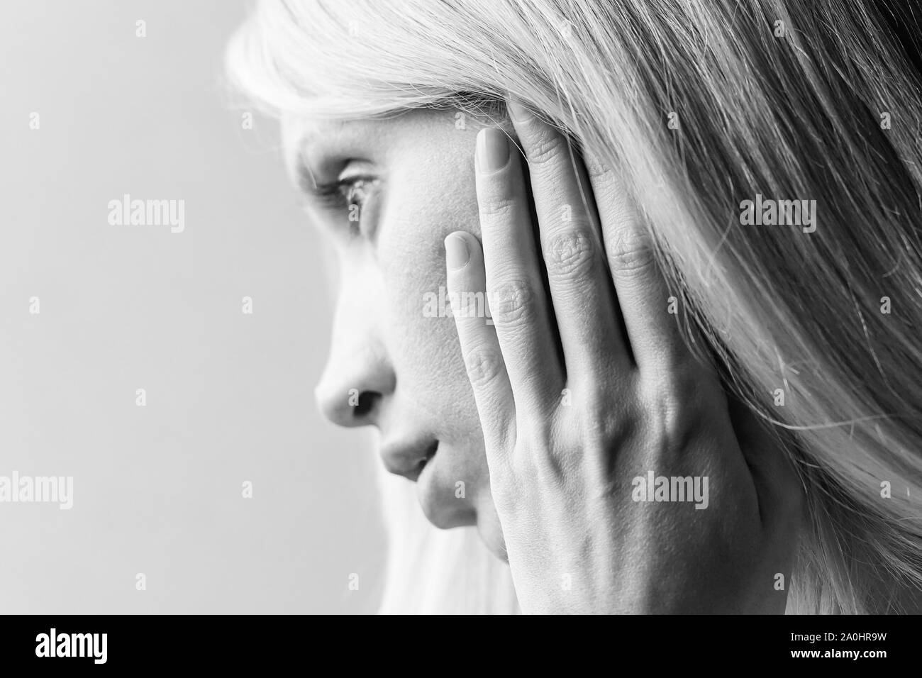 Soft portrait of a young girl with hand on her cheek, side view in ...