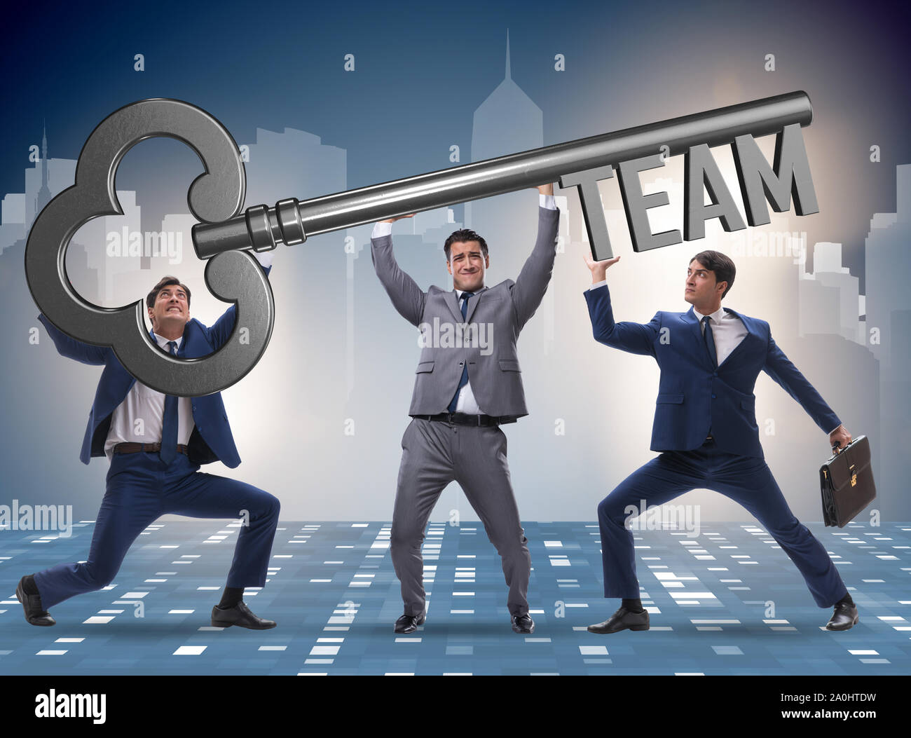 The businessmen holding giant key in team concept Stock Photo - Alamy