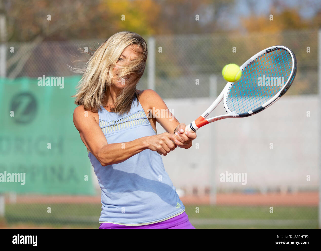 Woman playing tennis hitting a backhand shot Stock Photo - Alamy