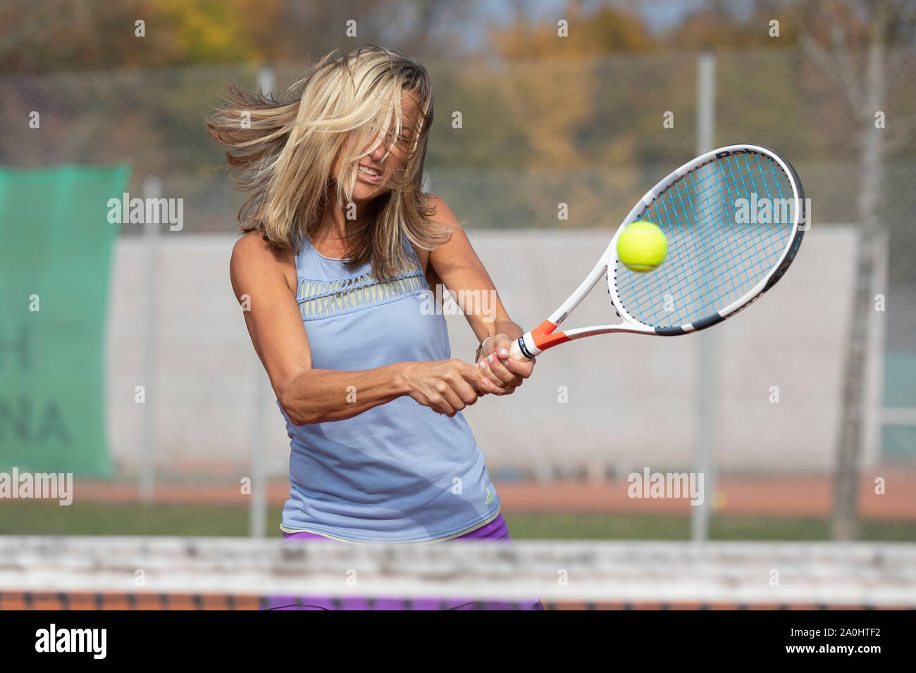 Mid adult woman hitting tennis ball hi-res stock photography and images ...