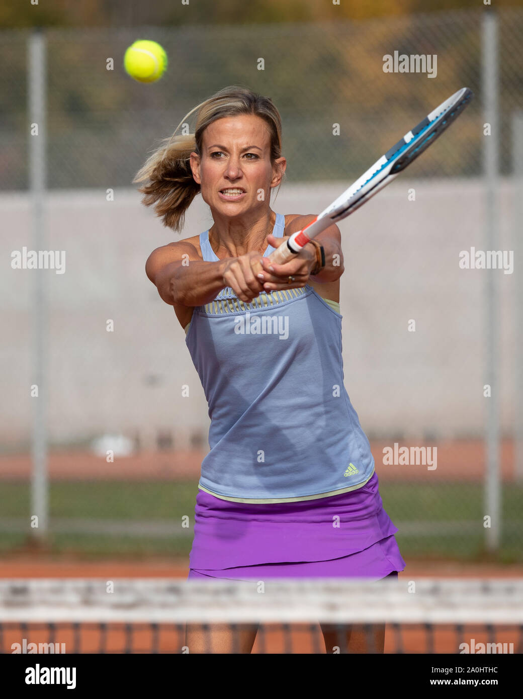 Mid adult woman hitting tennis ball hi-res stock photography and images ...