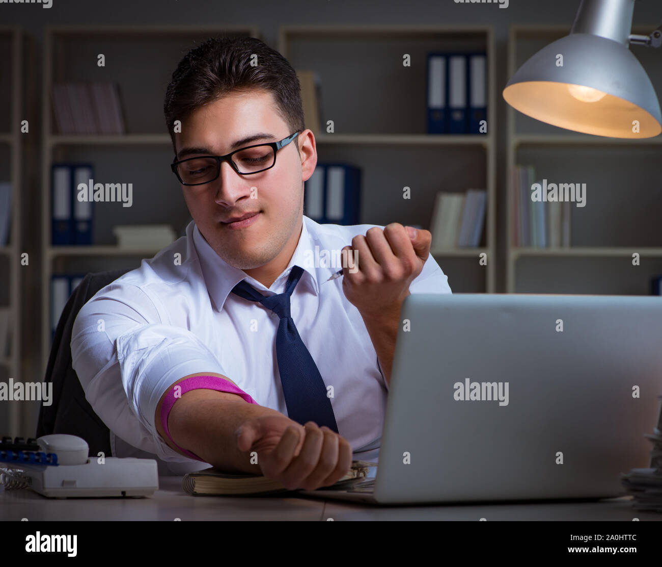 The businessman staying late in office for drugs Stock Photo - Alamy
