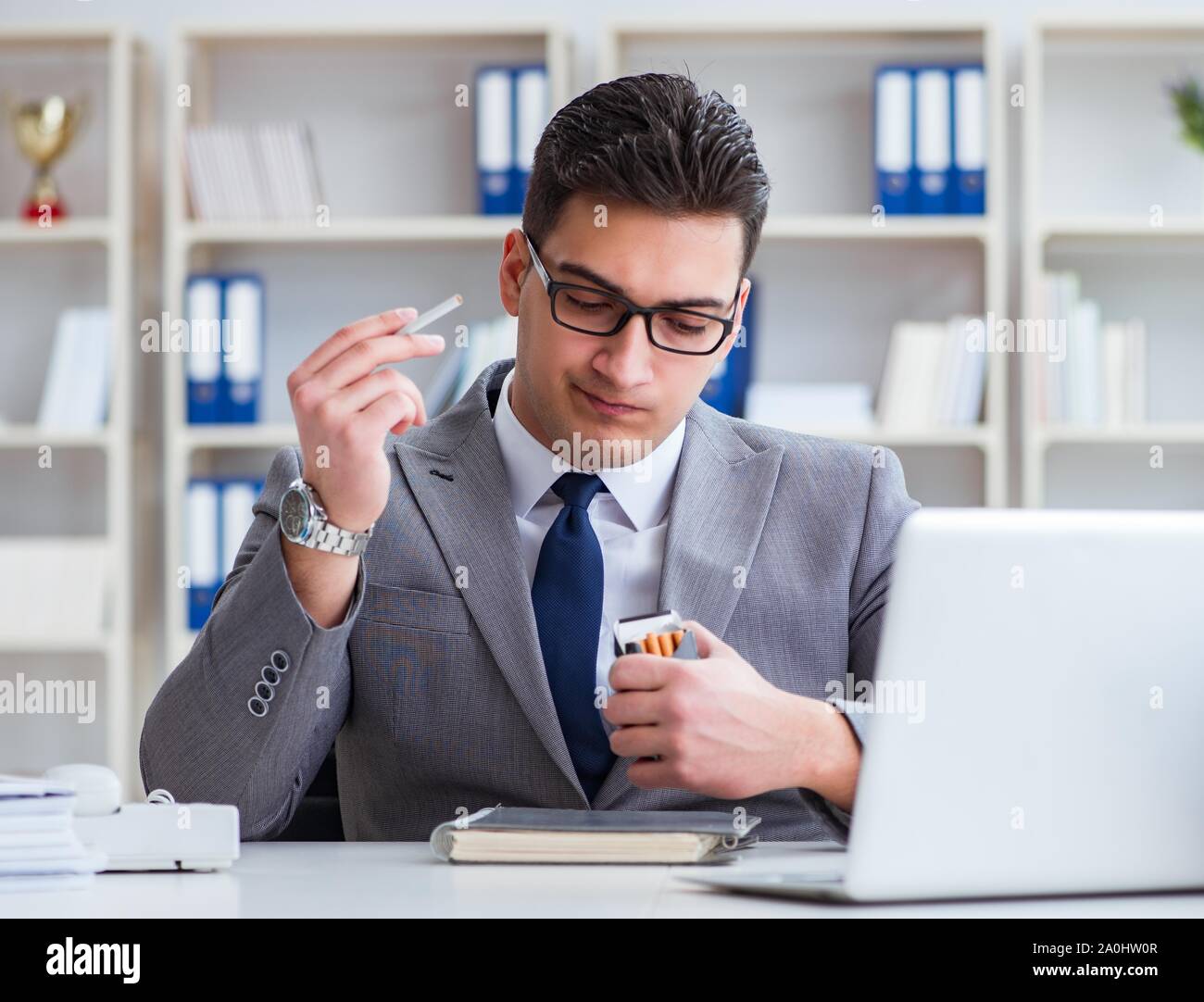 The businessman smoking in office at work Stock Photo - Alamy