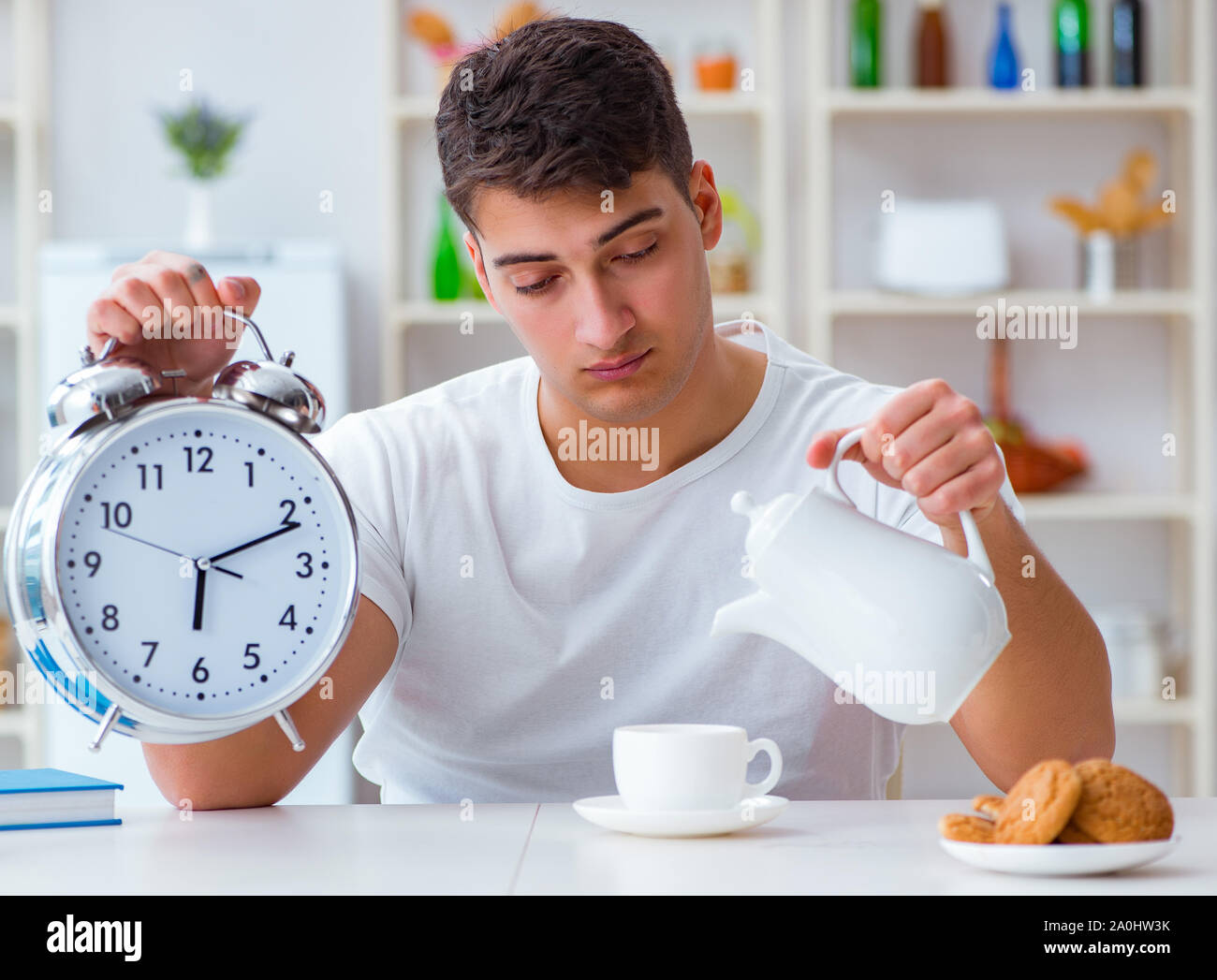 The man with alarm clock falling asleep at breakfast Stock Photo - Alamy