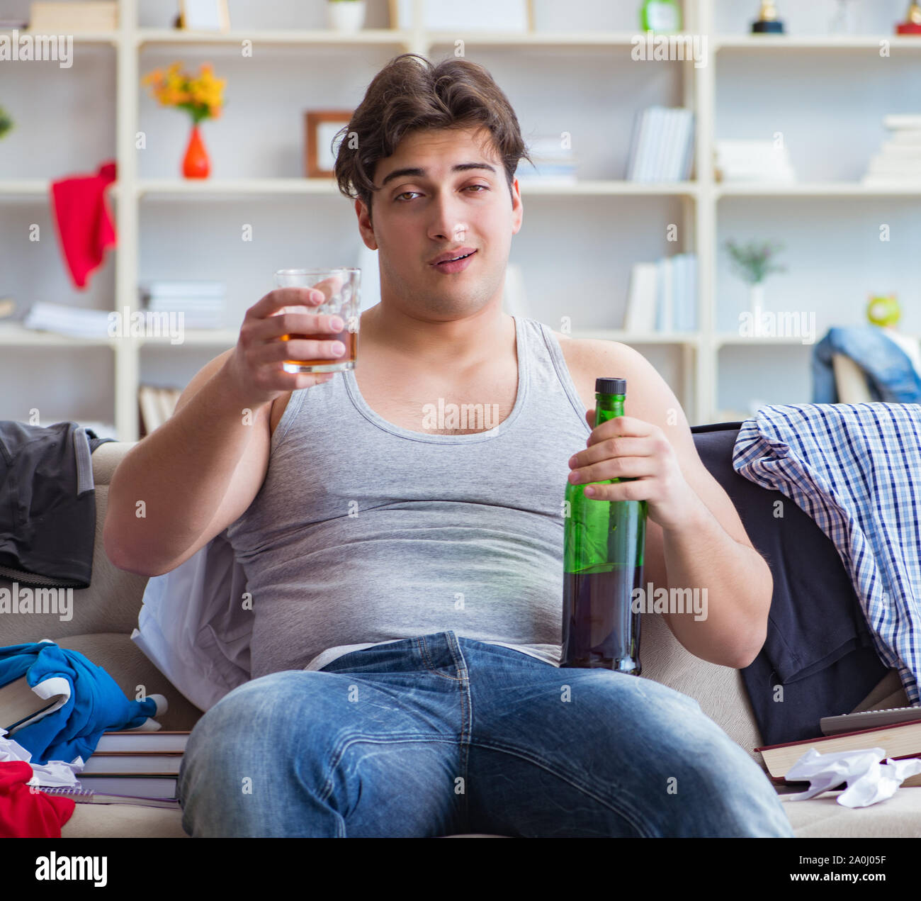 The young man student drunk drinking alcohol in a messy room Stock ...